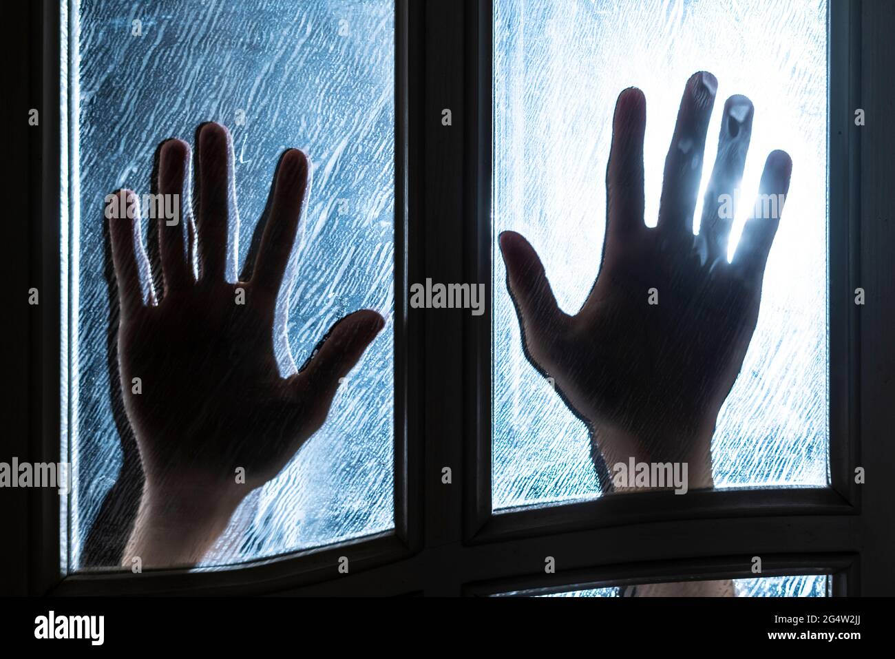 horror scene of hand placed on door window at night time Stock Photo ...
