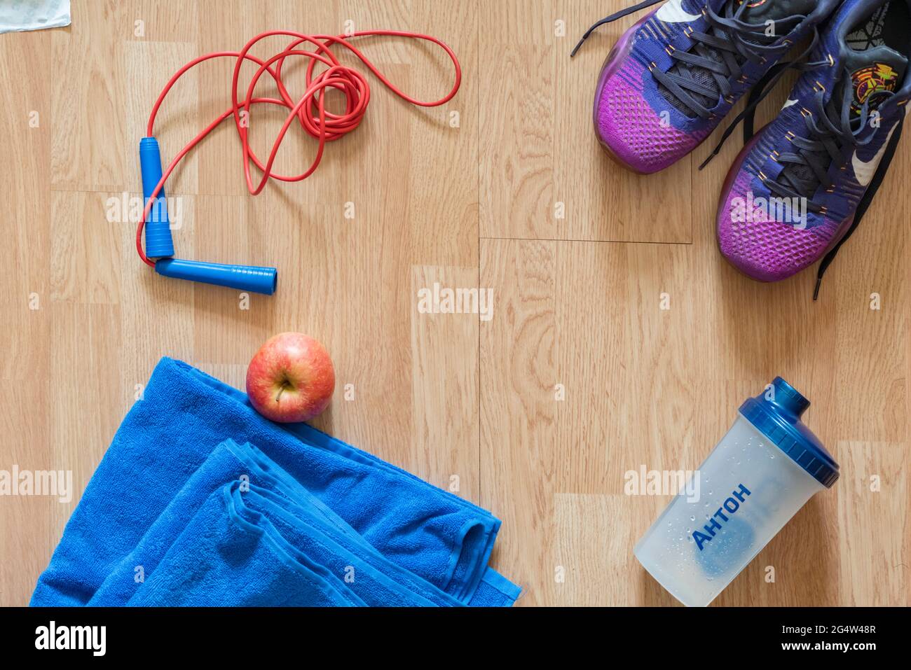 flat lay gym equipment such as jump rope sneakers and towel with apple ...