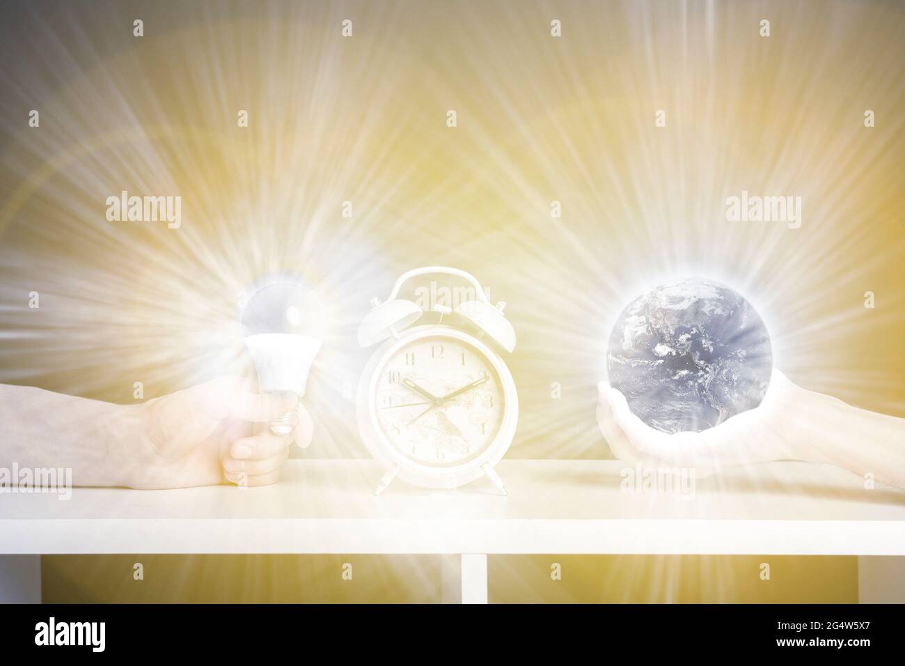 hand hold earth near alarm clock. earth hour concept Stock Photo - Alamy