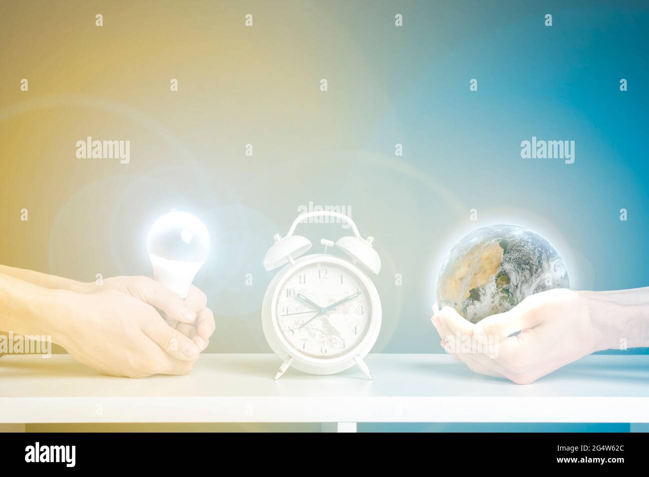 hand hold earth near alarm clock. earth hour concept Stock Photo - Alamy