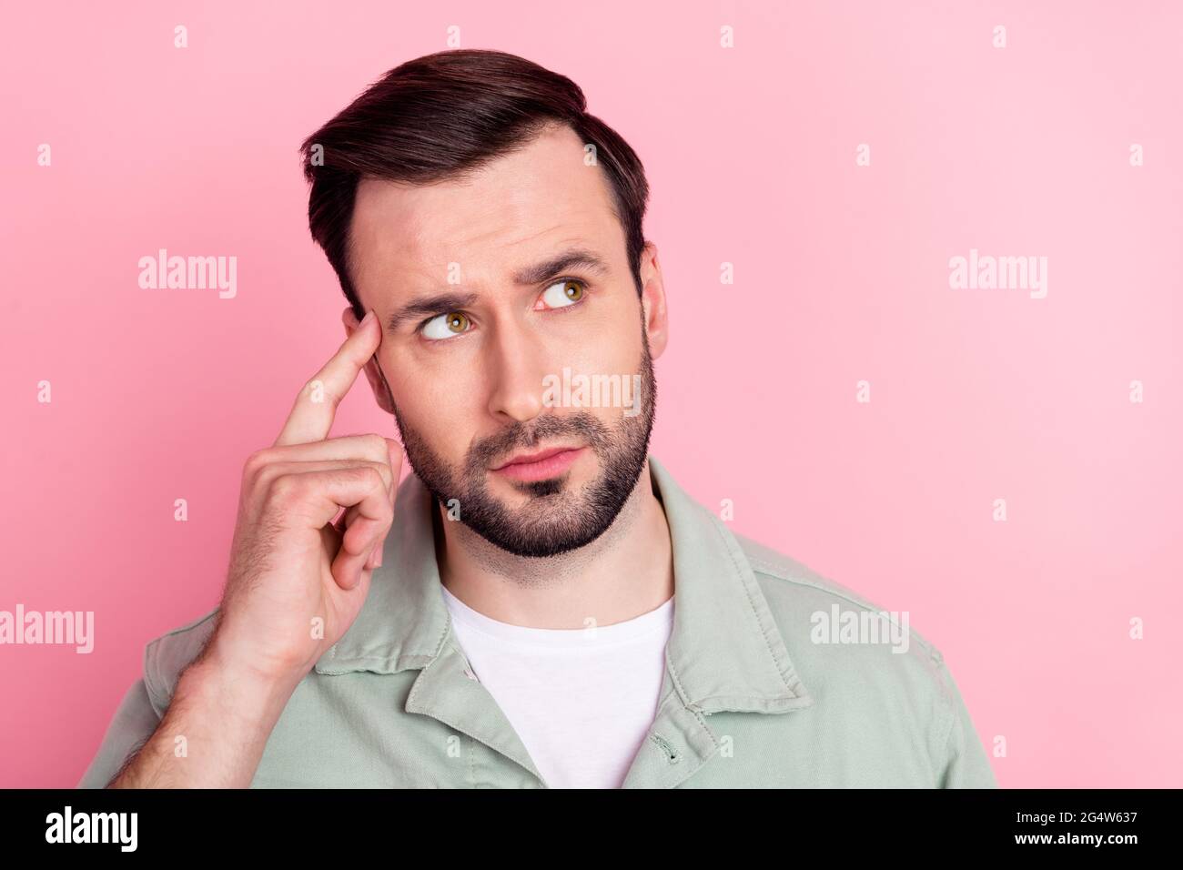 Photo of nice serious brunet man finger head look empty space wear grey ...