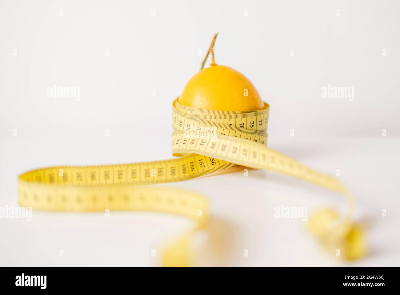 fruit and centimeter tape on white surface. diet concept Stock Photo ...