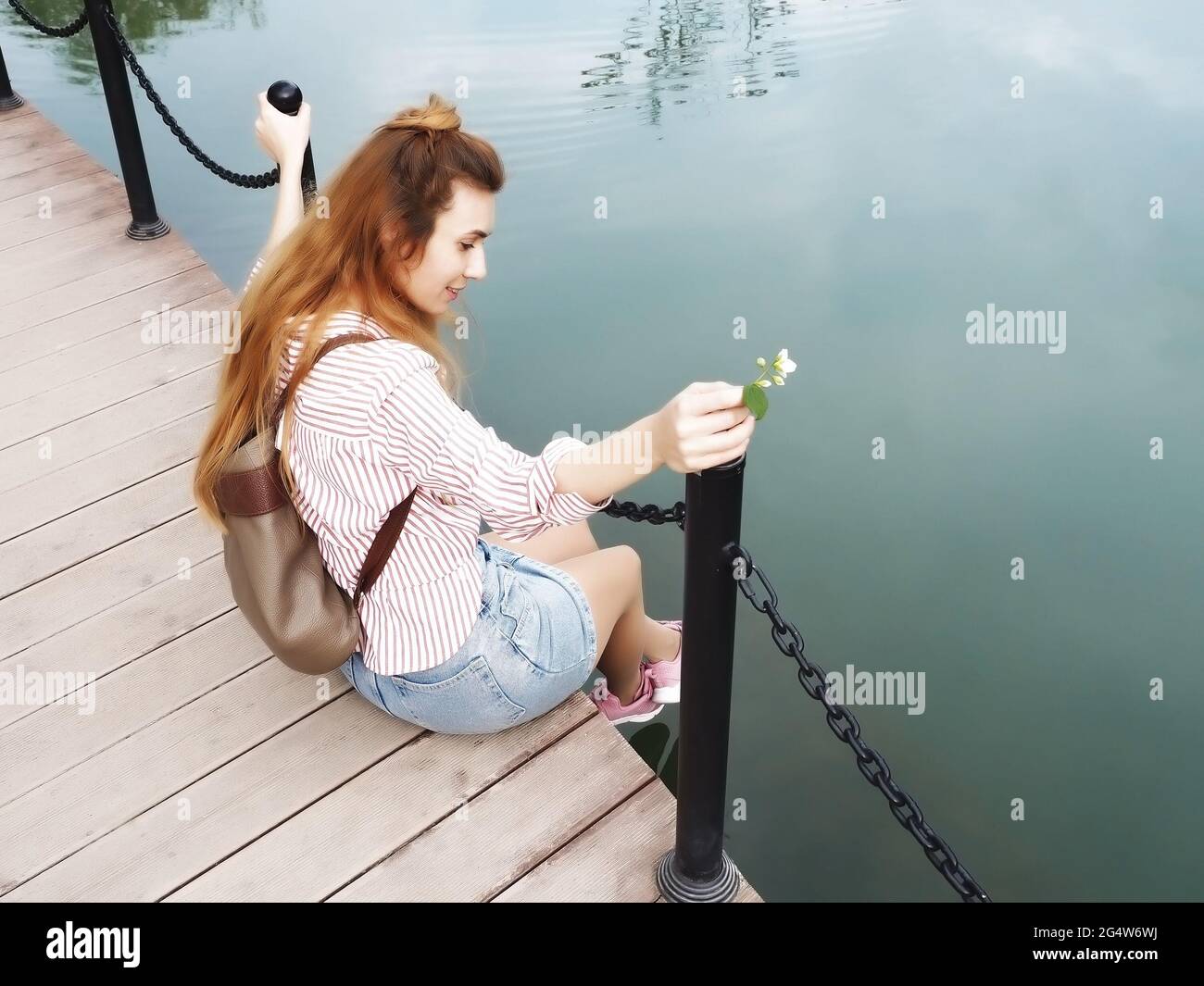 Woman dangling her legs over the water hi-res stock photography and ...