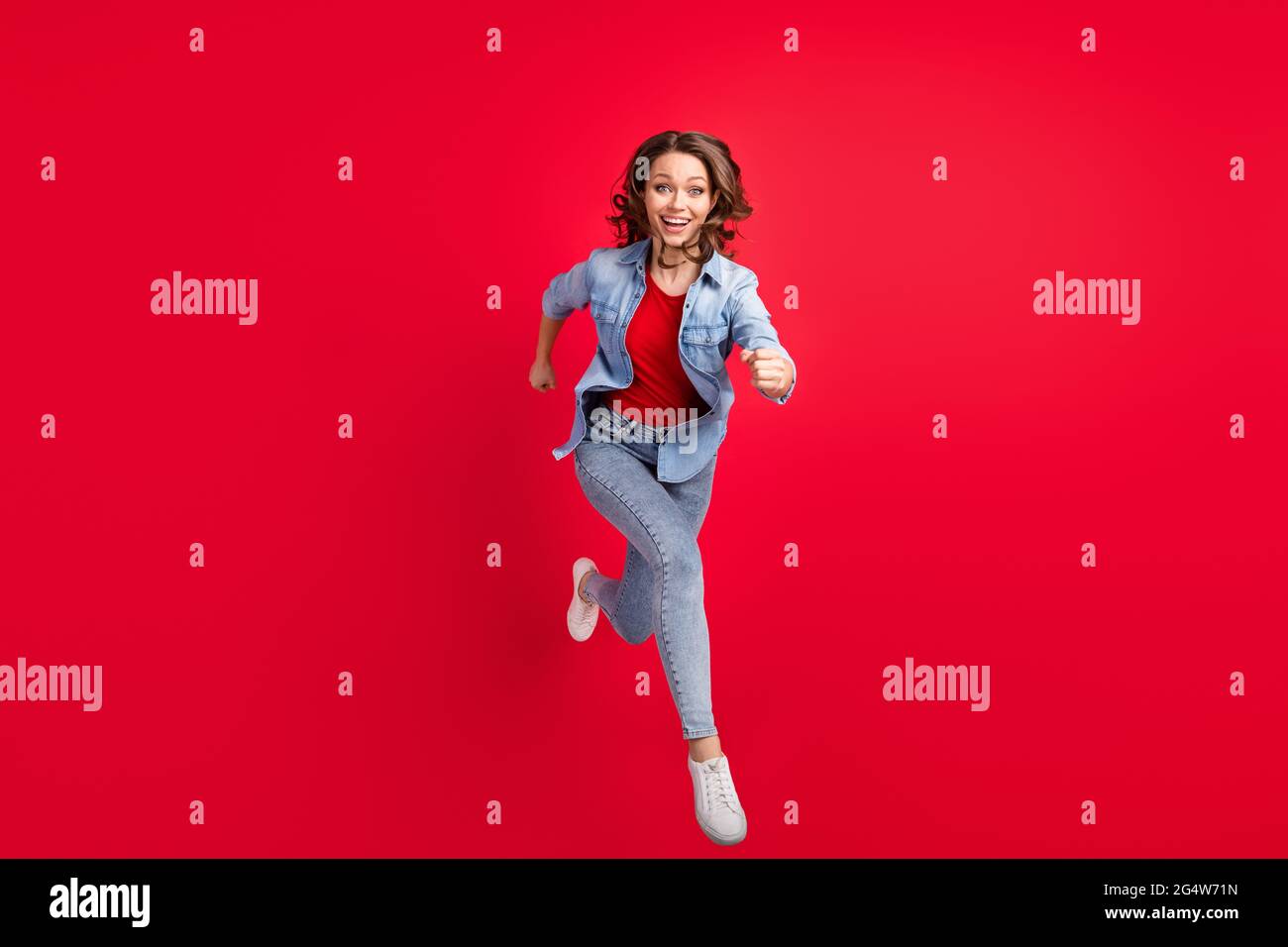 Photo of impressed sweet young lady dressed denim outfit jumping high ...