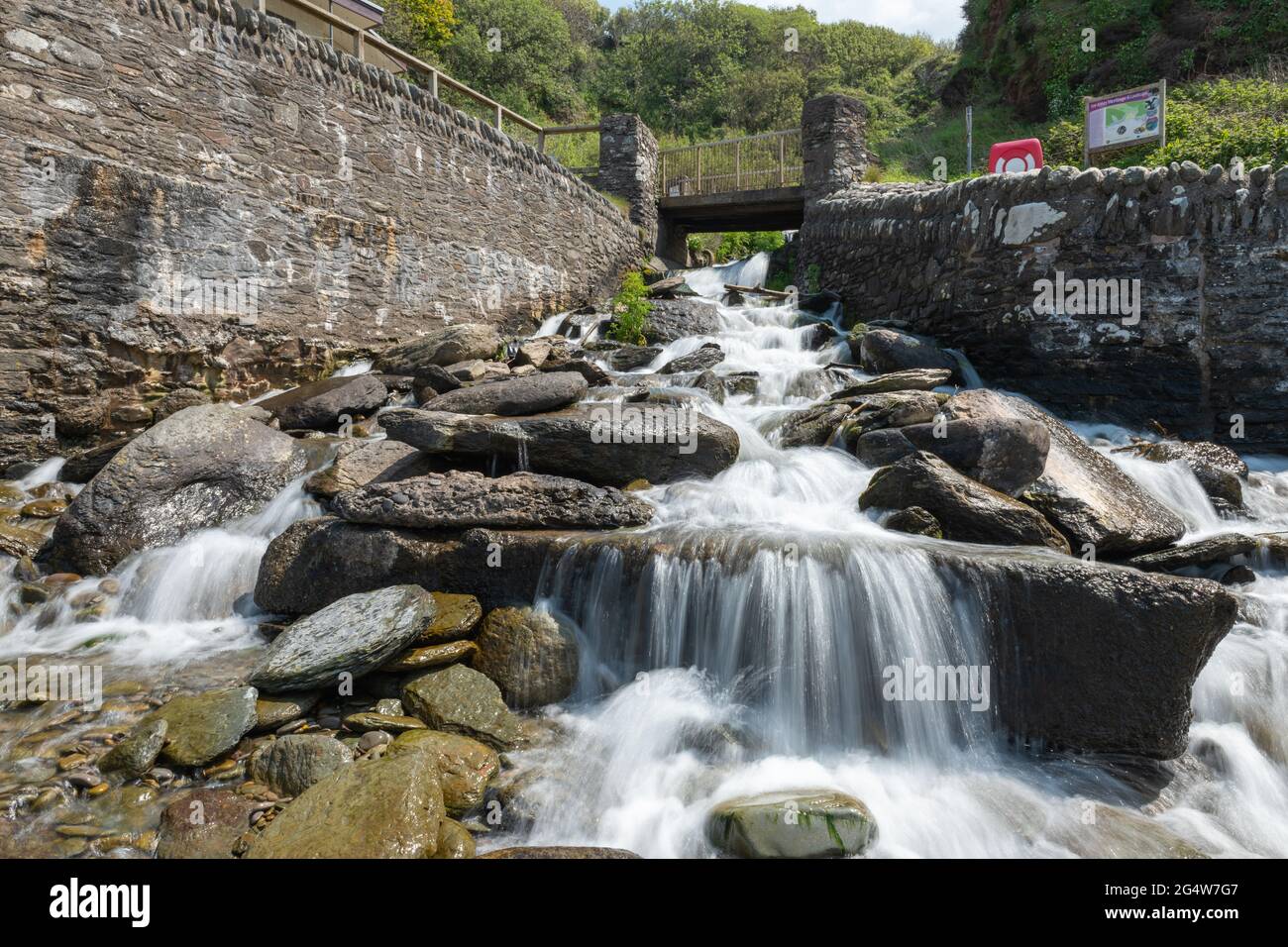Long exposure of a waterfall flowing onto Lee Abbey Beach in Devon ...