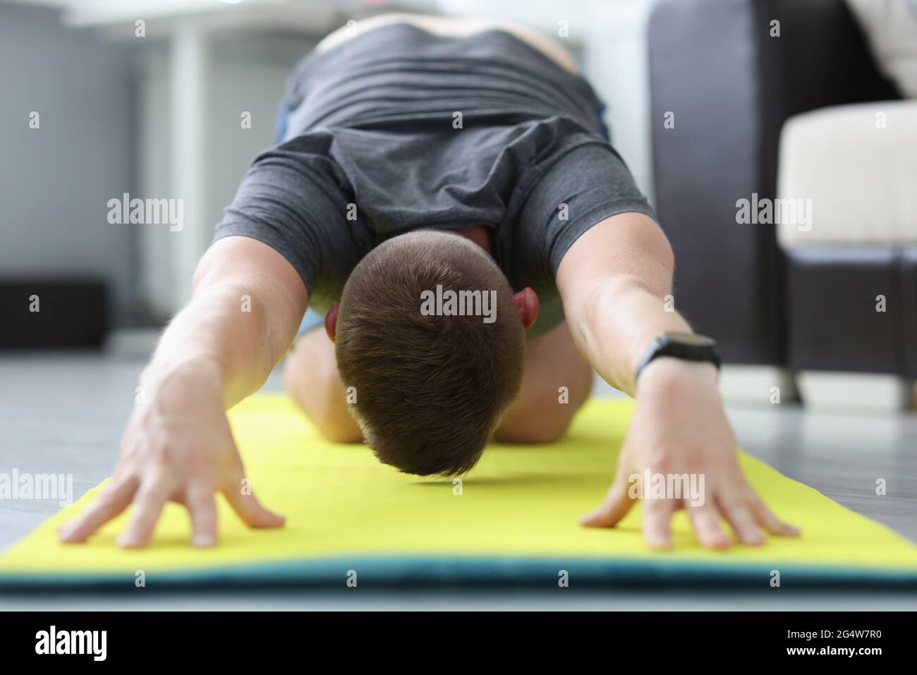 Young man is doing exercises to stretch his back muscles Stock Photo ...