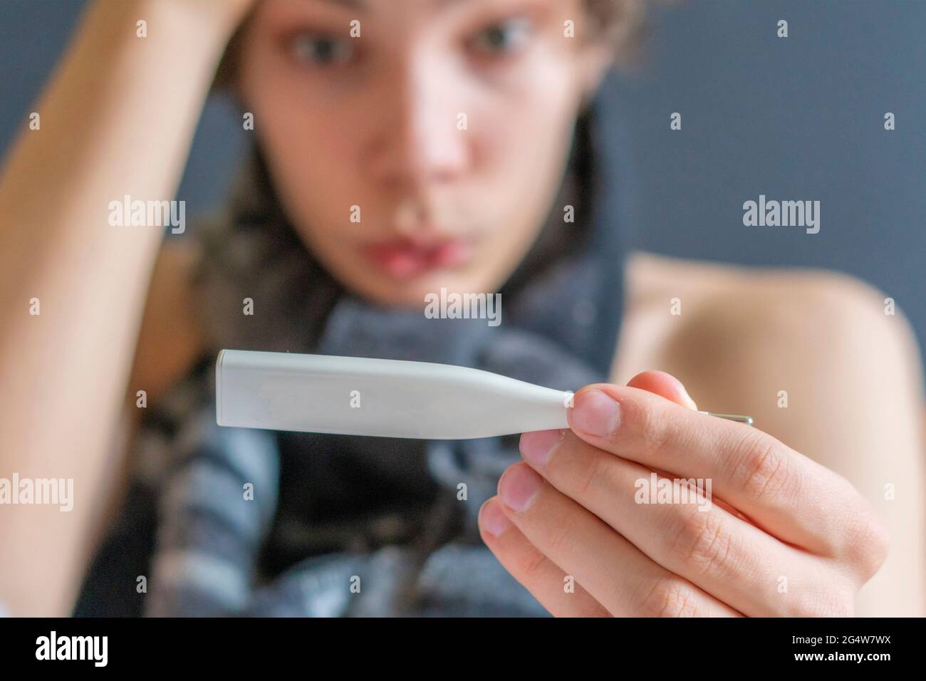 sad teenager lay in bed and hold thermometer. illness concept Stock ...