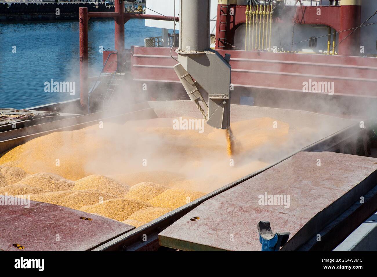 Corn in bulk carrier hold. Casting hold of corn. Elevator crane loads ...