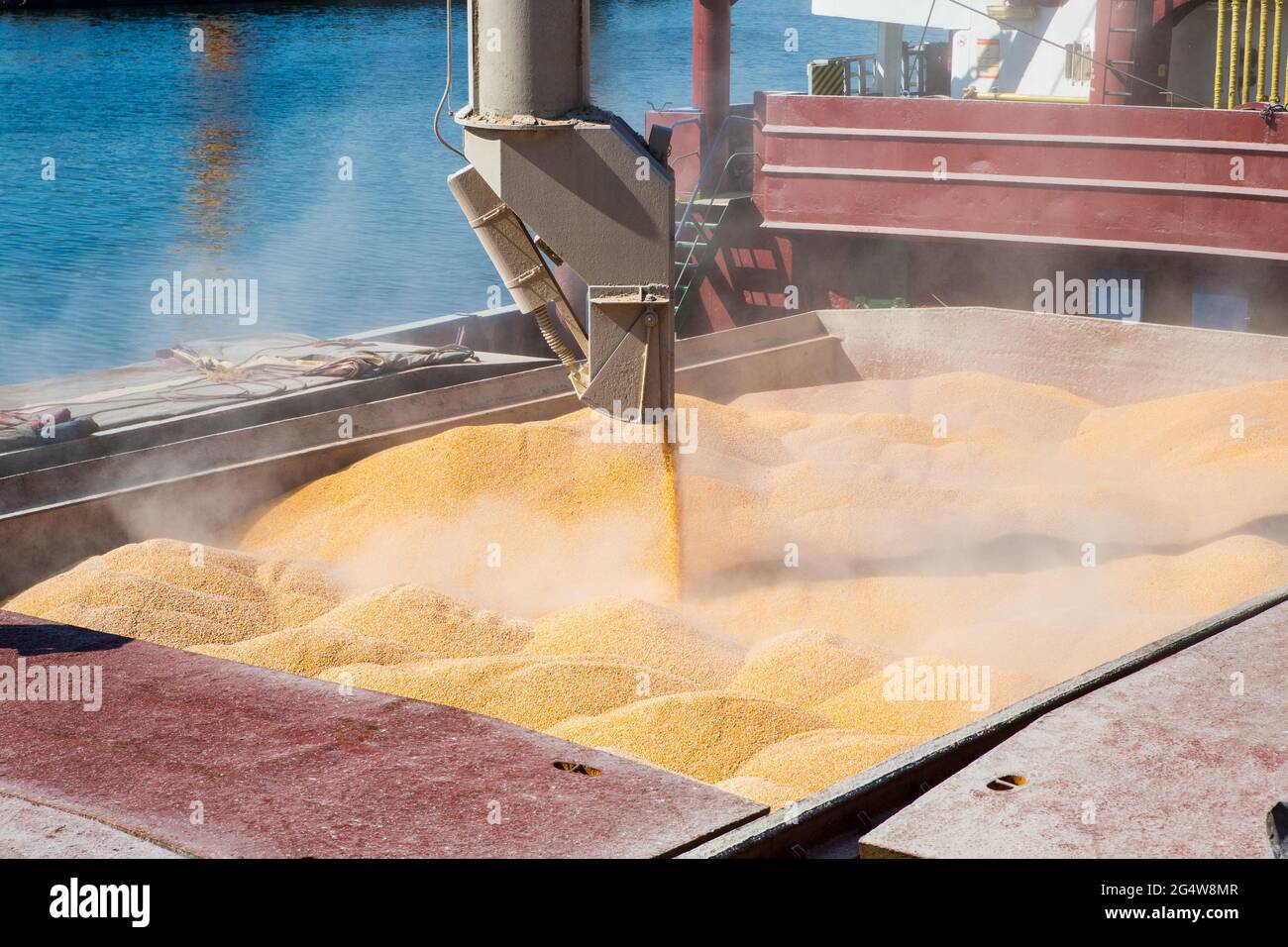 Corn in bulk carrier hold. Casting hold of corn. Elevator crane loads ...