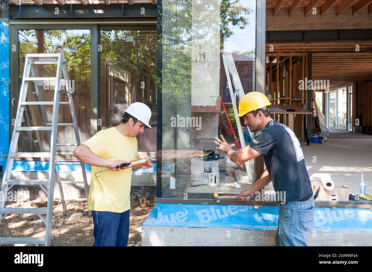 Construction workers working installing European style windows in a ...