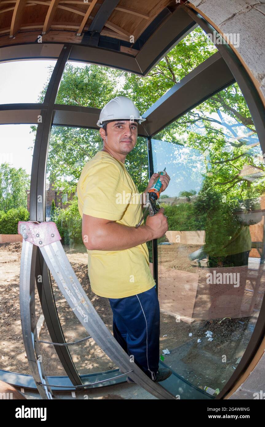 Construction workers working installing European style windows in a ...