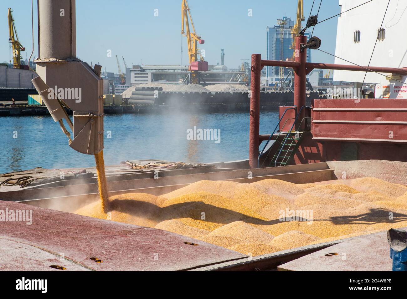 Corn in bulk carrier hold. Casting hold of corn. Elevator crane loads ...