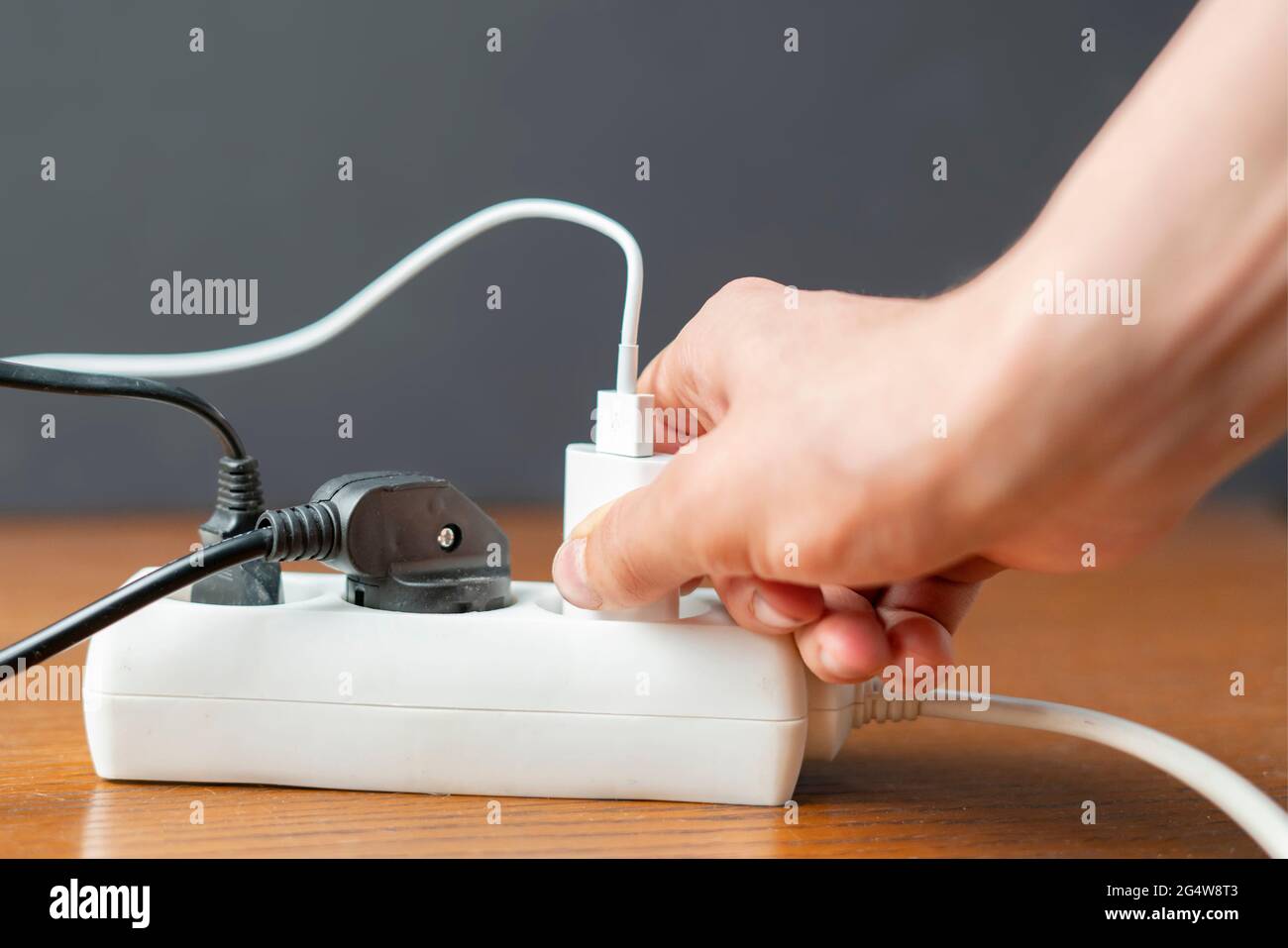 close up persons hand plug electrical charge in socket Stock Photo - Alamy