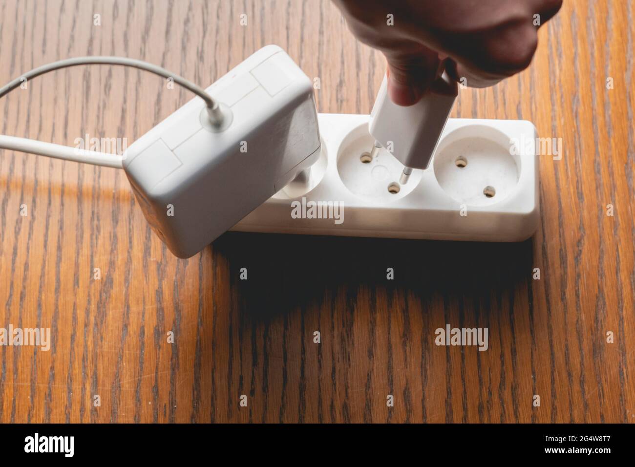 close up persons hand plug electrical charge in socket Stock Photo - Alamy