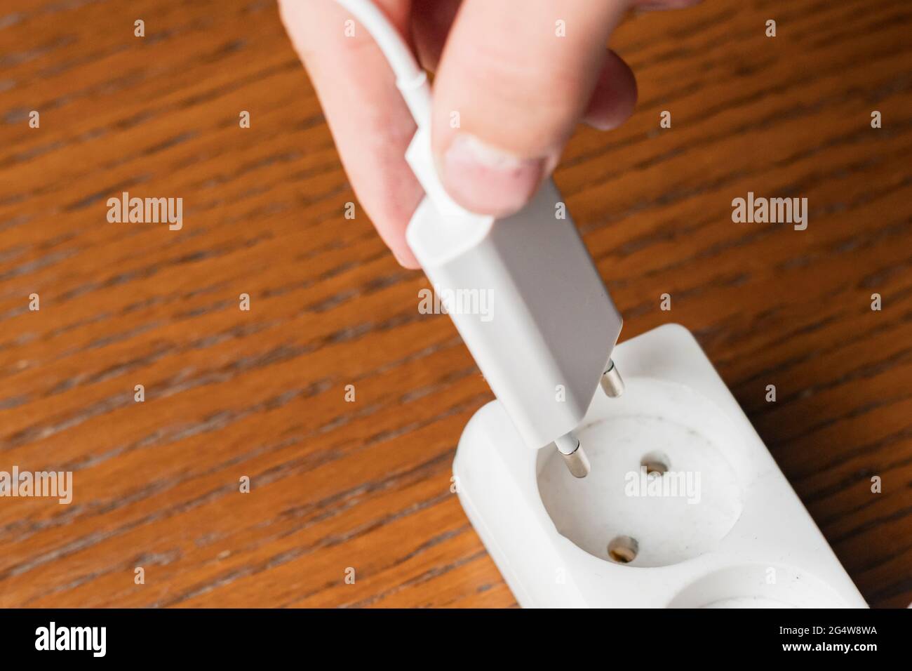 close up persons hand plug electrical charge in socket Stock Photo - Alamy