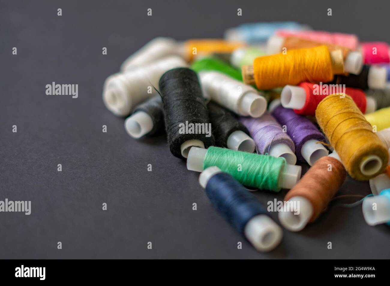 bunch of colorful sew threads lay on dark background isolated Stock ...