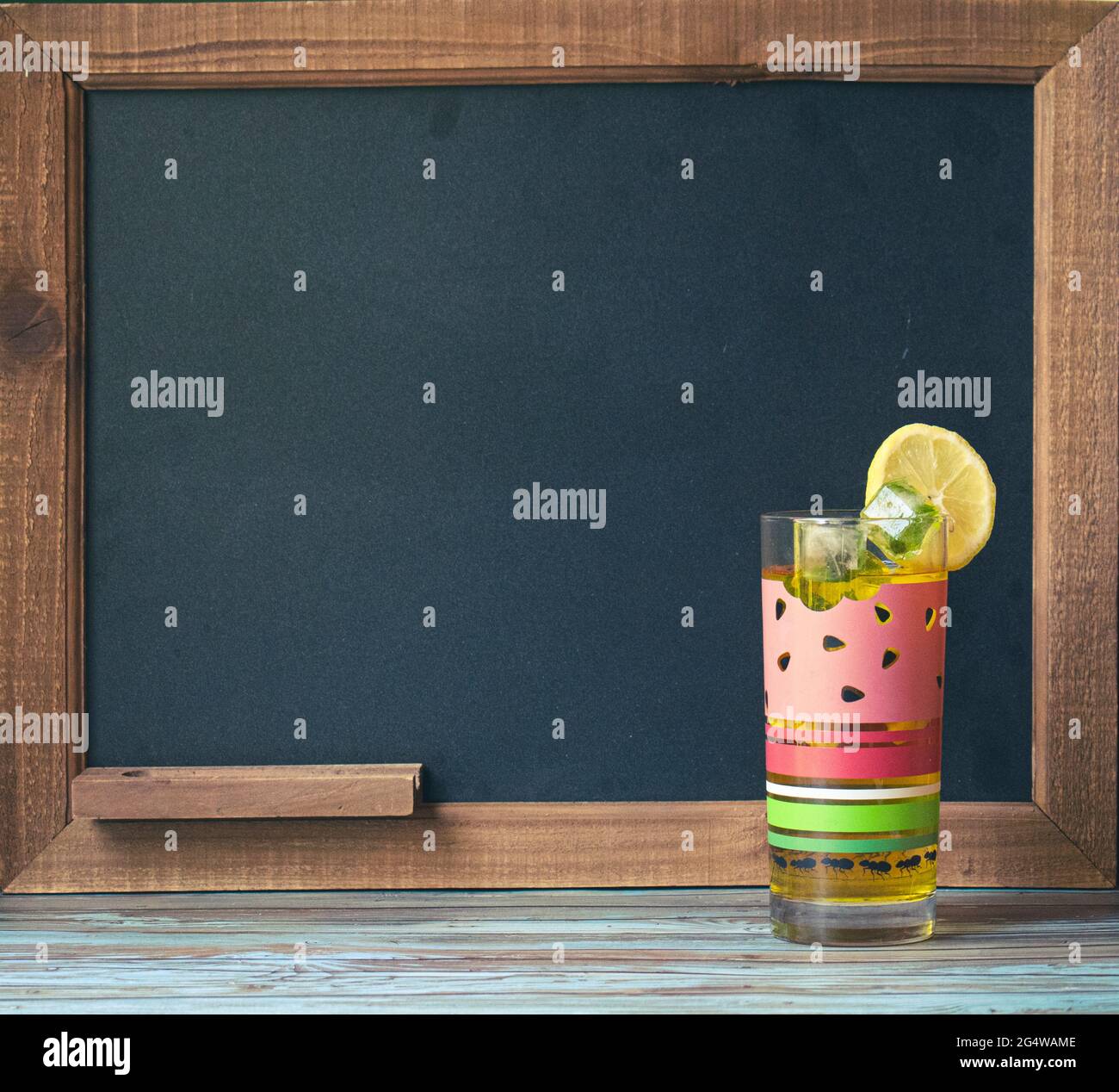 Cocktail drink in front of chalkboard for the drink menu, with tropical ...