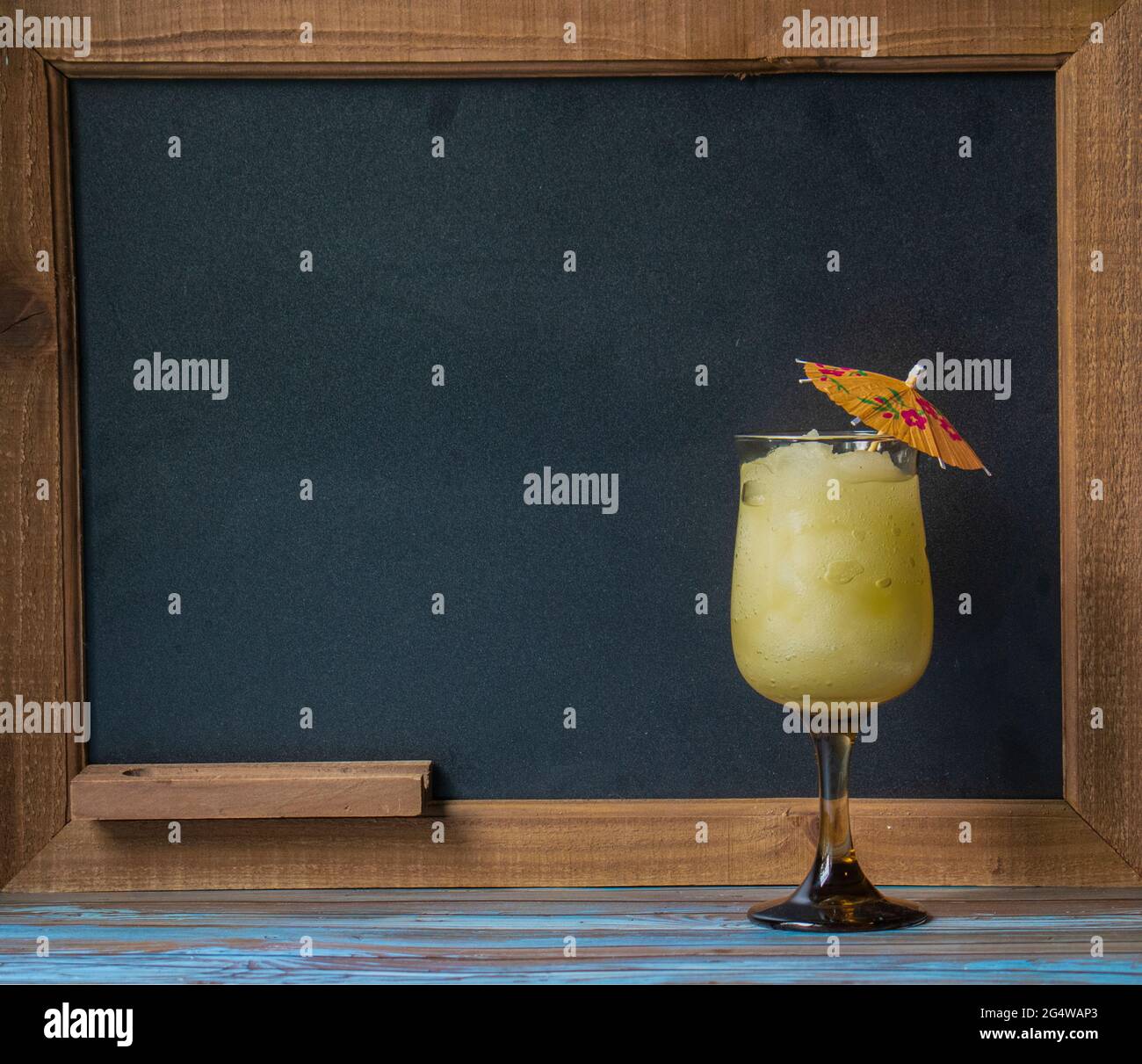 Cocktail drink in front of chalkboard for the drink menu, with tropical ...