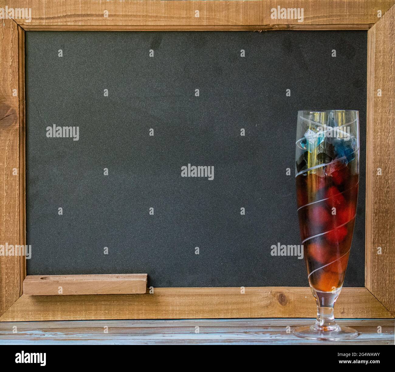 Cocktail drink in front of chalkboard for the drink menu, with tropical ...