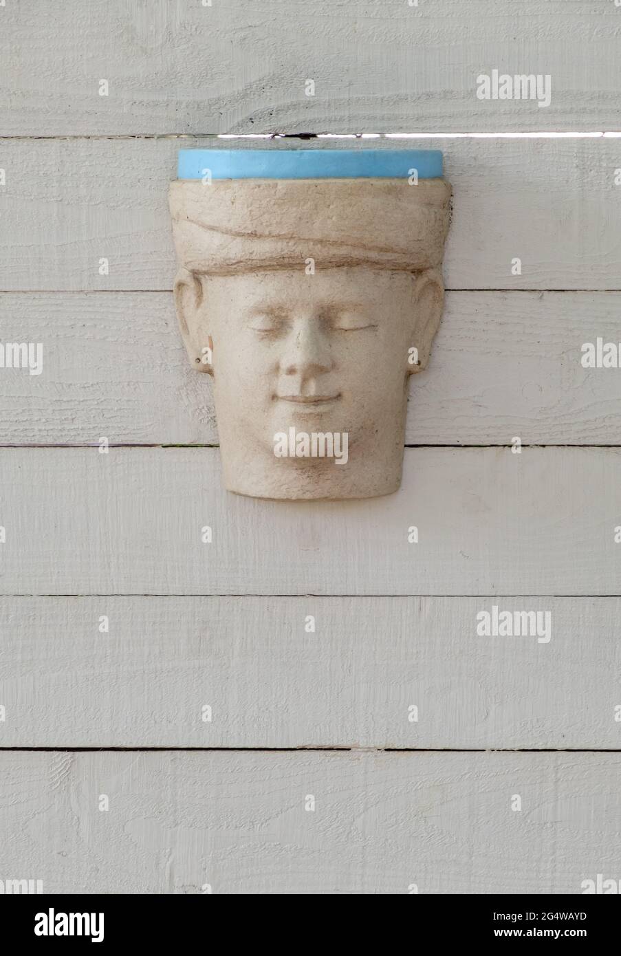 Closeup of the human face sculpture for the plant pot is hanging on the ...
