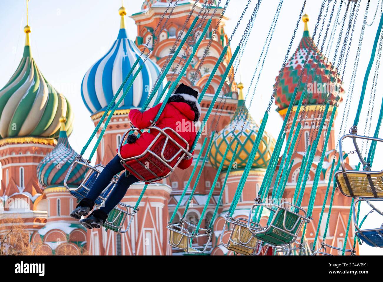 child having fun riding on a chain carousel in the amusement park Stock ...