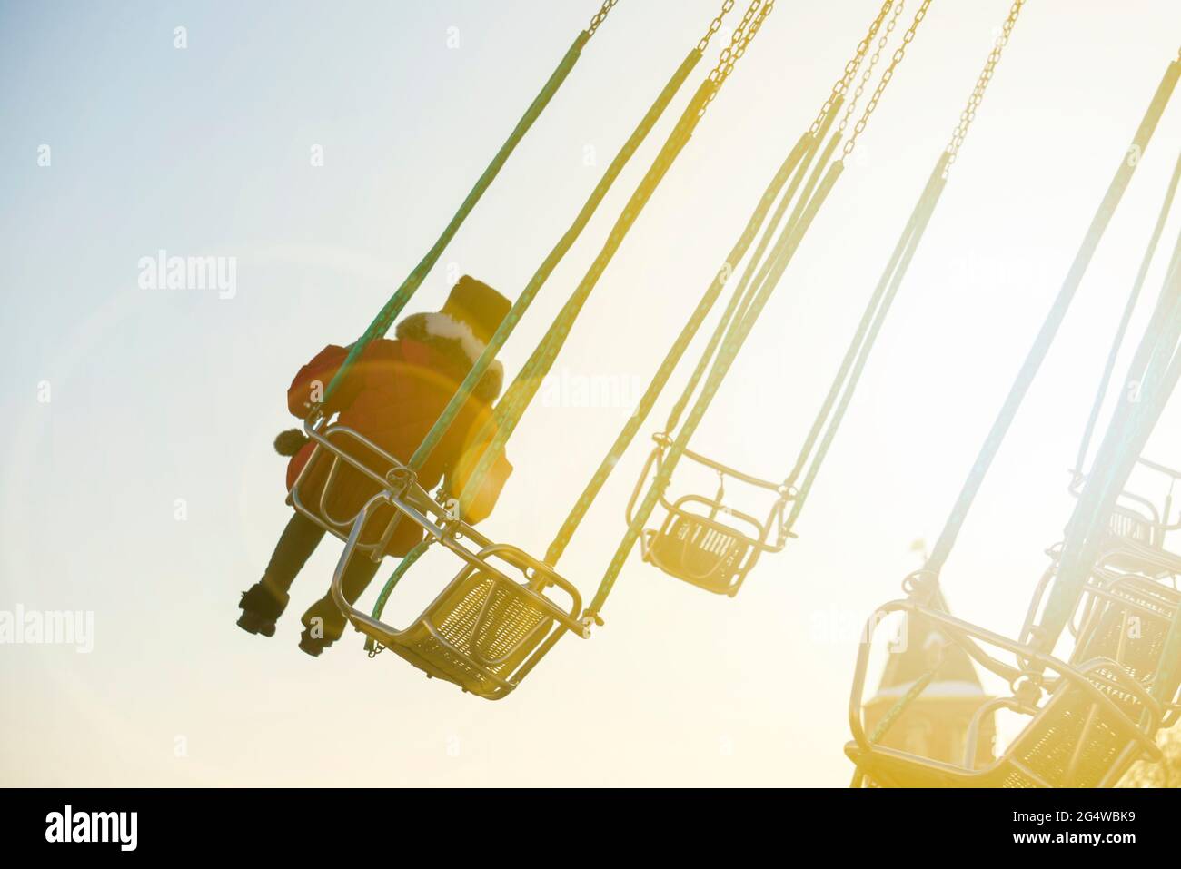 child having fun riding on a chain carousel in the amusement park Stock ...