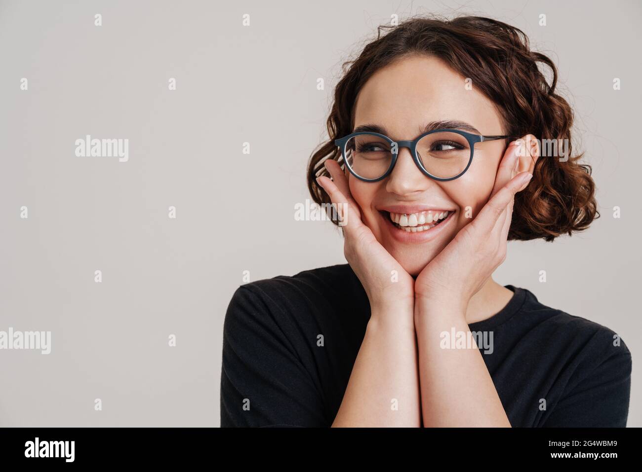 Happy smiling beautiful young woman presenting looking at copyspace ...
