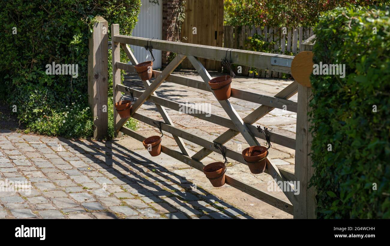 Closed wooden gate with plant pots attached Stock Photo - Alamy