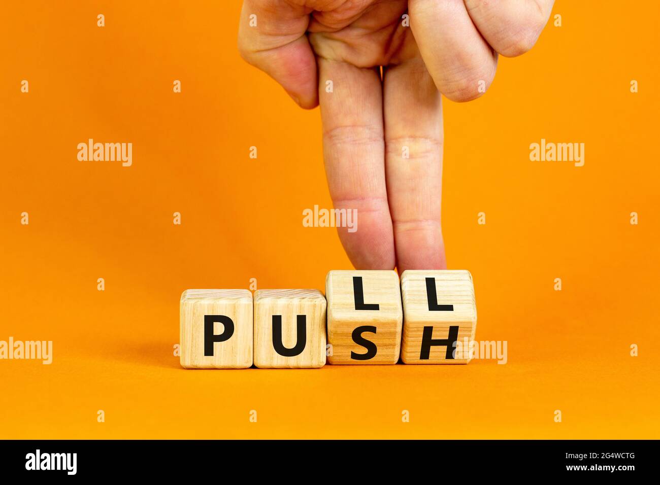 Pull or push symbol. Businessman turns wooden cubes and changes the ...