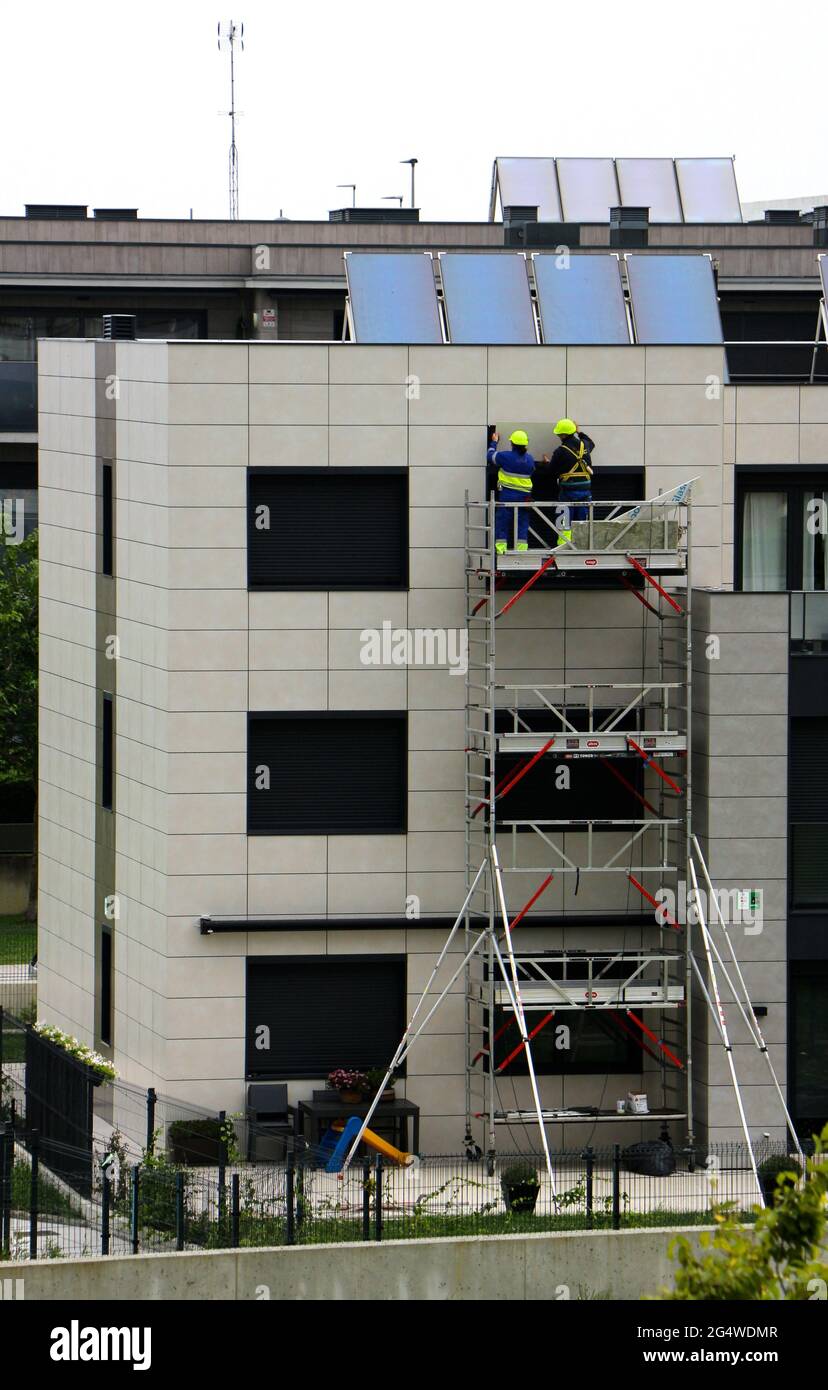 Two workmen repairing water ingression behind cladding on a 1 year old ...
