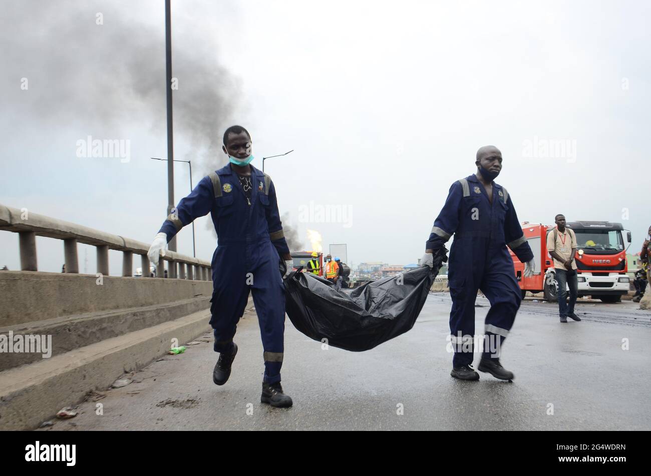 Men of Lagos State Emergency Management Agency carrying the remains of ...