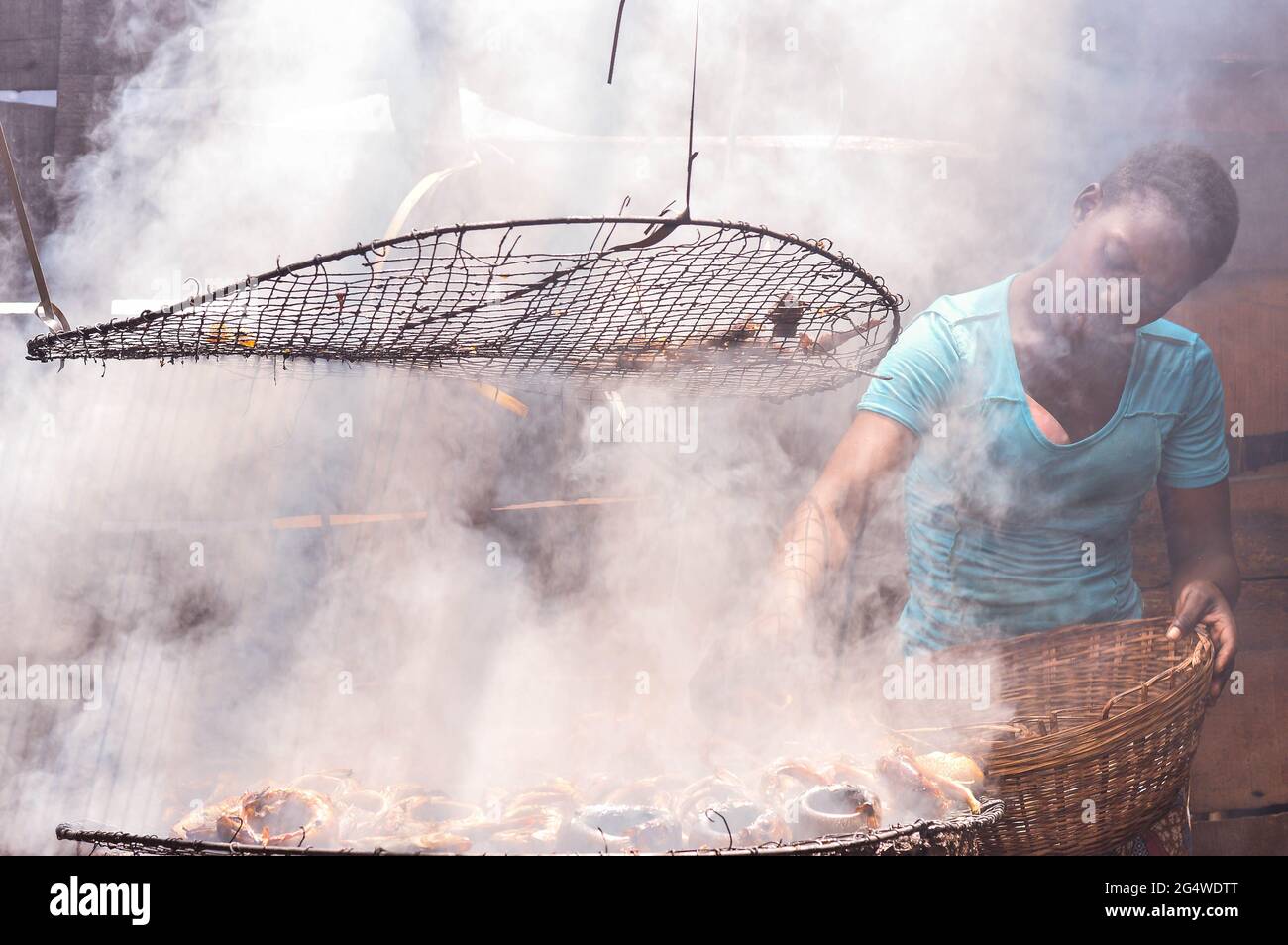 A girl prepares smoked fish at Makoko shanty town in Lagos. Nigeria ...