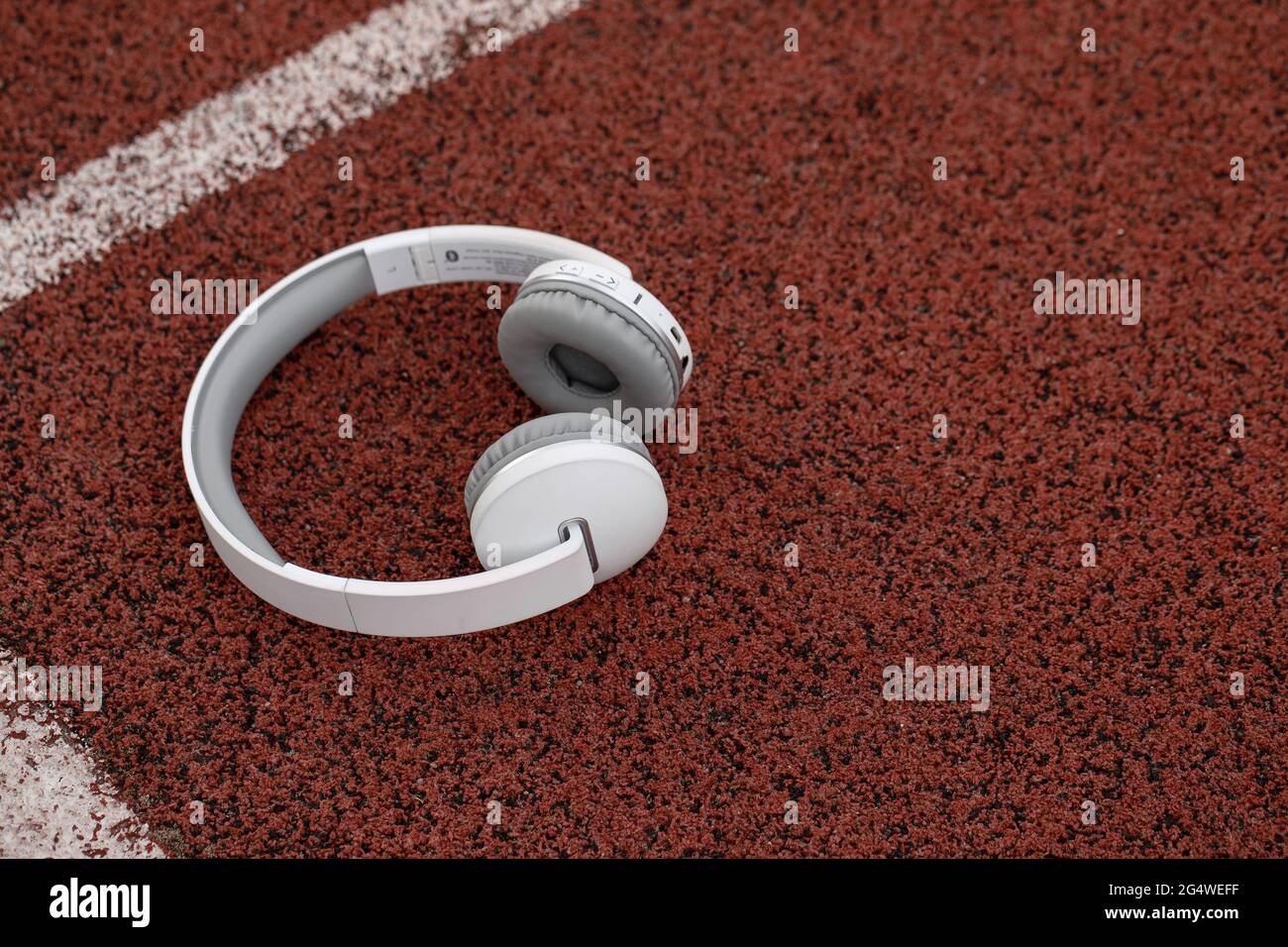 wireless white headphones on red racing track rubber background Stock ...