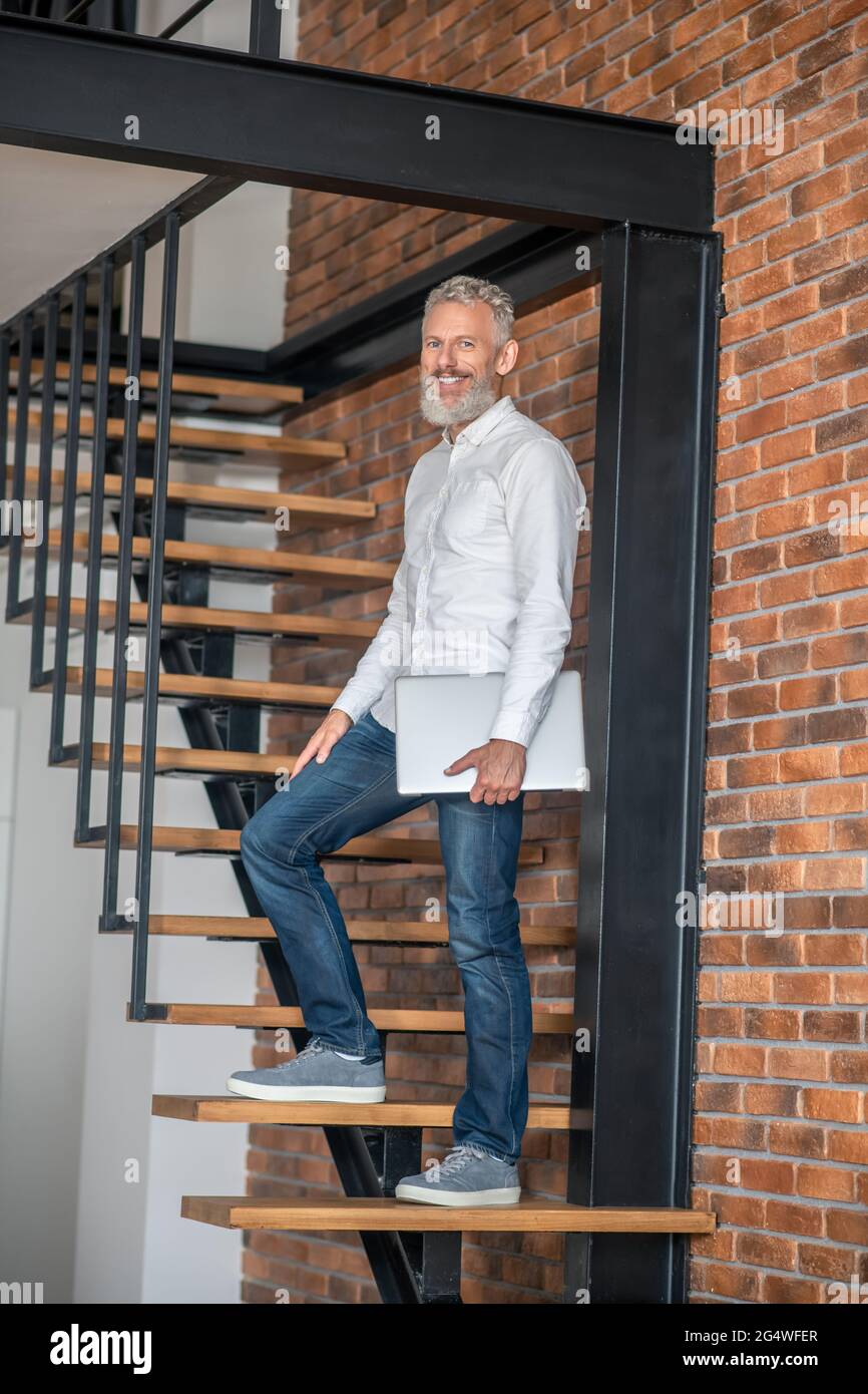 Mature tall mid-aged man standing on the stairs Stock Photo - Alamy