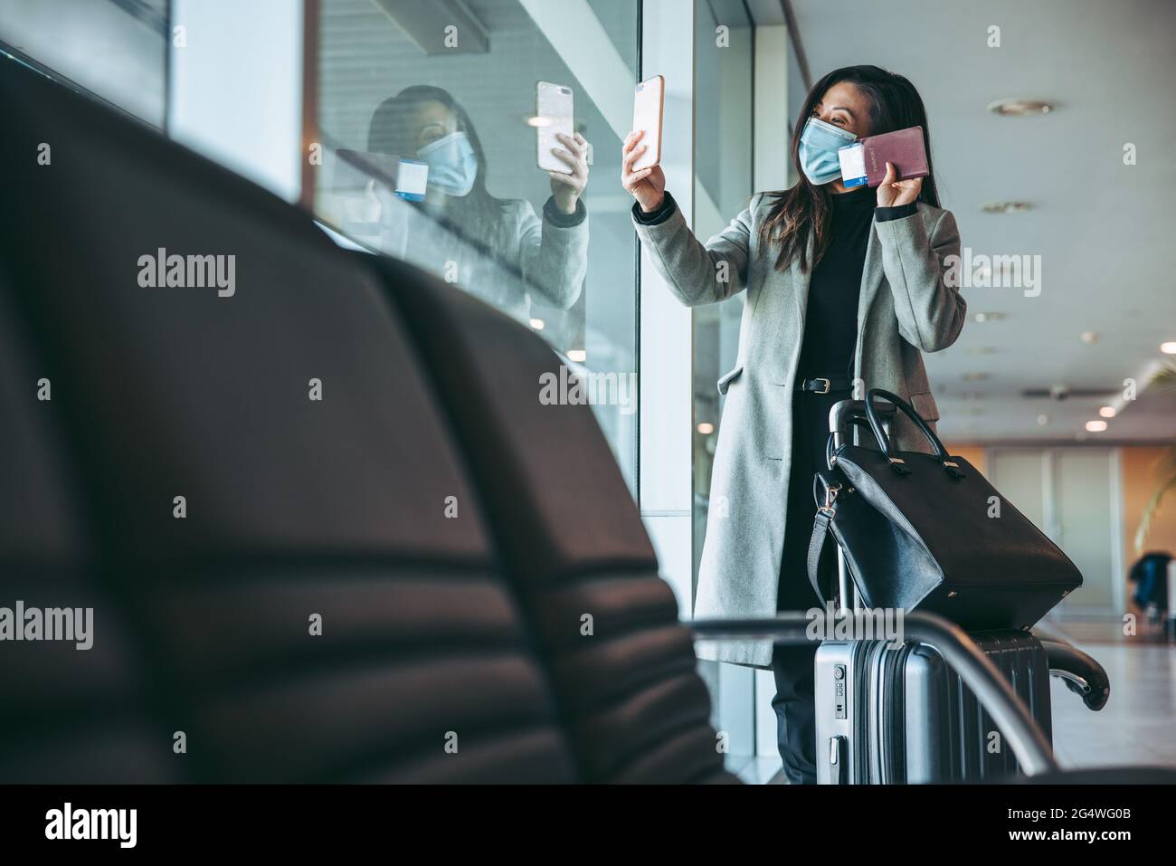 Woman wearing face mask video calling with her cell phone and showing ...