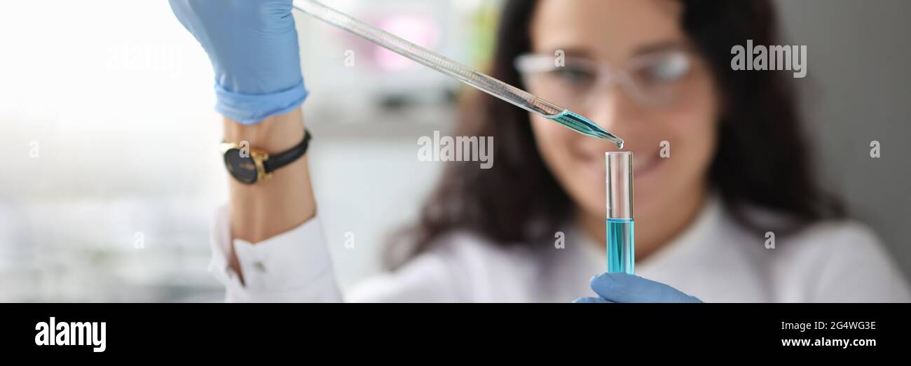 Woman chemist dripping blue liquid into test tube closeup Stock Photo ...