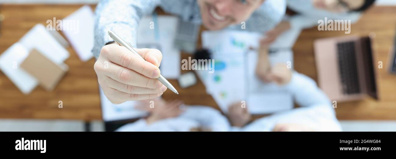 Group of business people are sitting at table top view. Man pointing ...