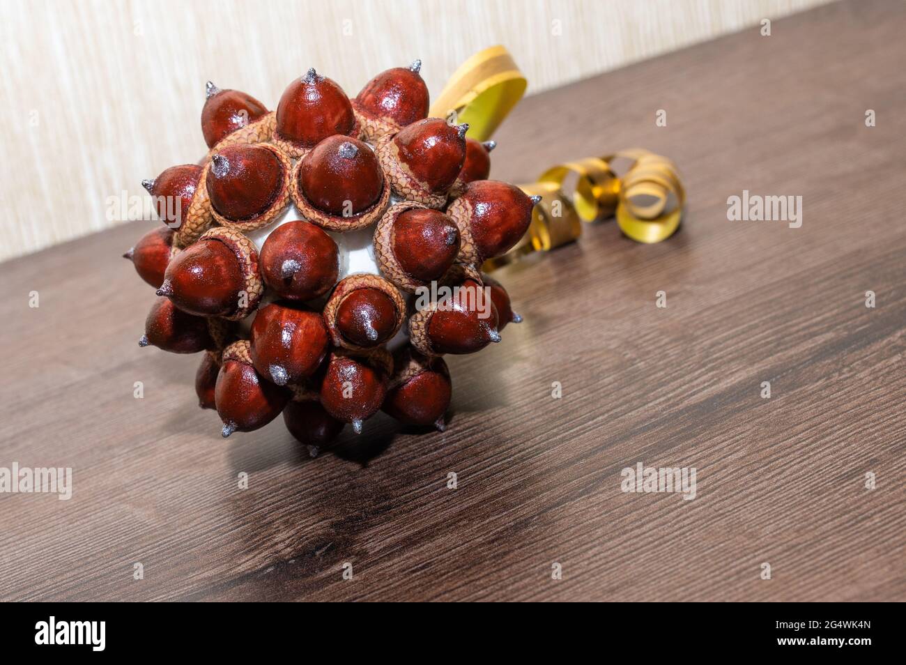 Handmade round decoration from oak acorns on the golden string Stock ...