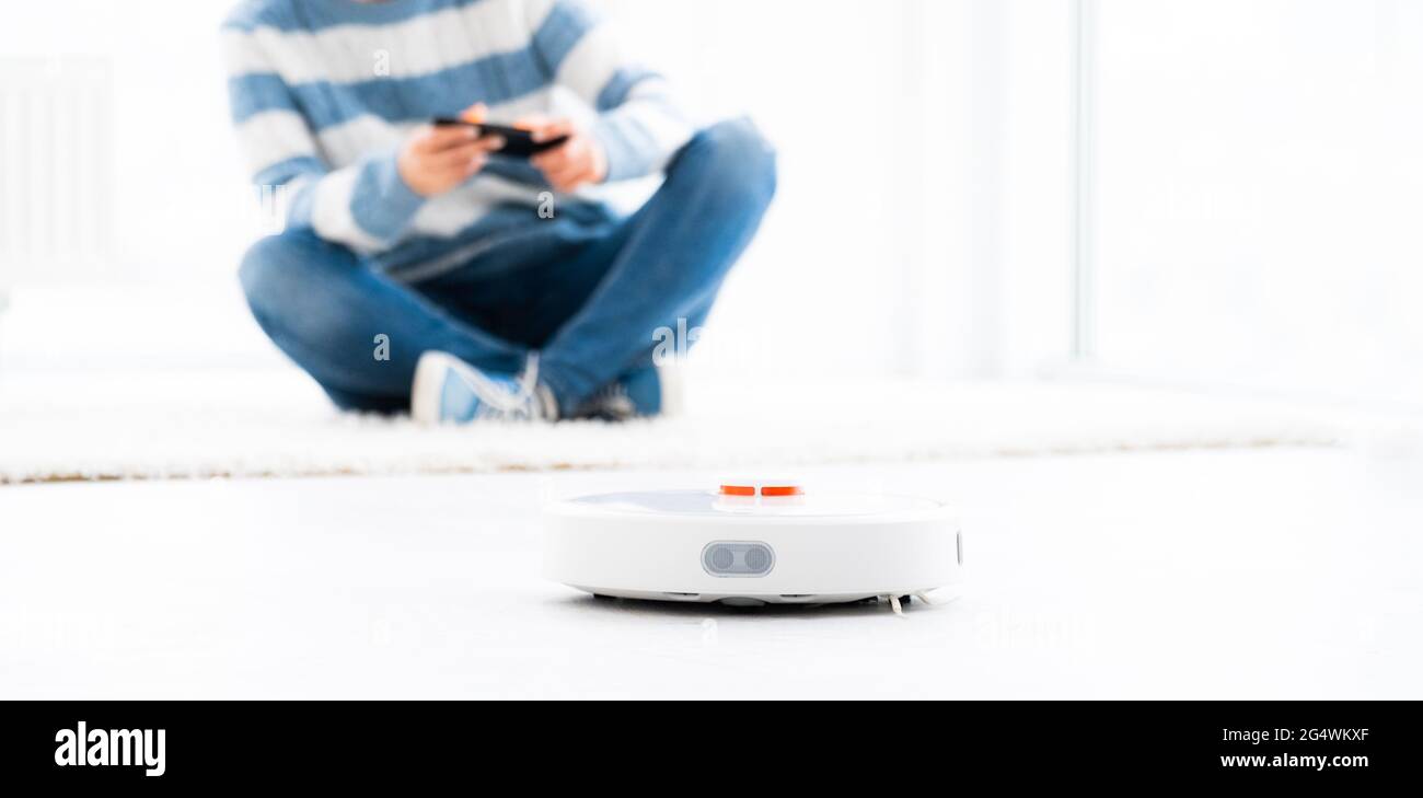 Person using remote control robot hoover Stock Photo - Alamy