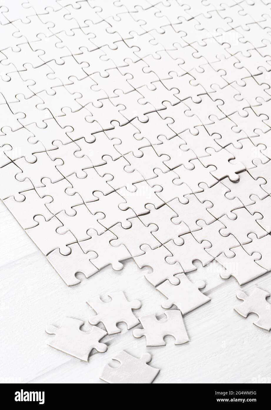 Little white pieces completing big blank puzzle Stock Photo - Alamy