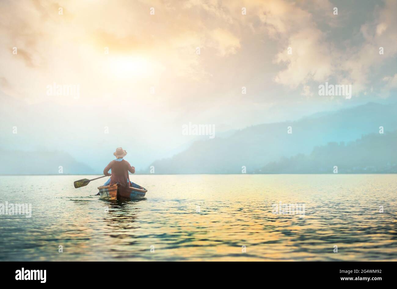 Back view of lonely fisherman in boat on morning lake Stock Photo - Alamy