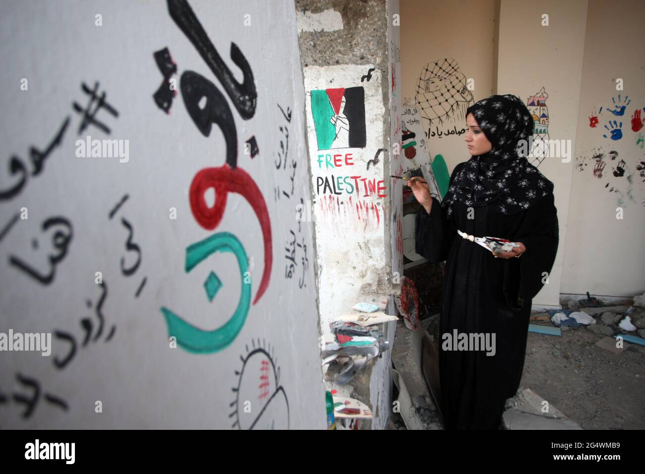 Rafah, Gaza. 23rd June, 2021. Palestinian artist Saja Moussa, 26, draws ...