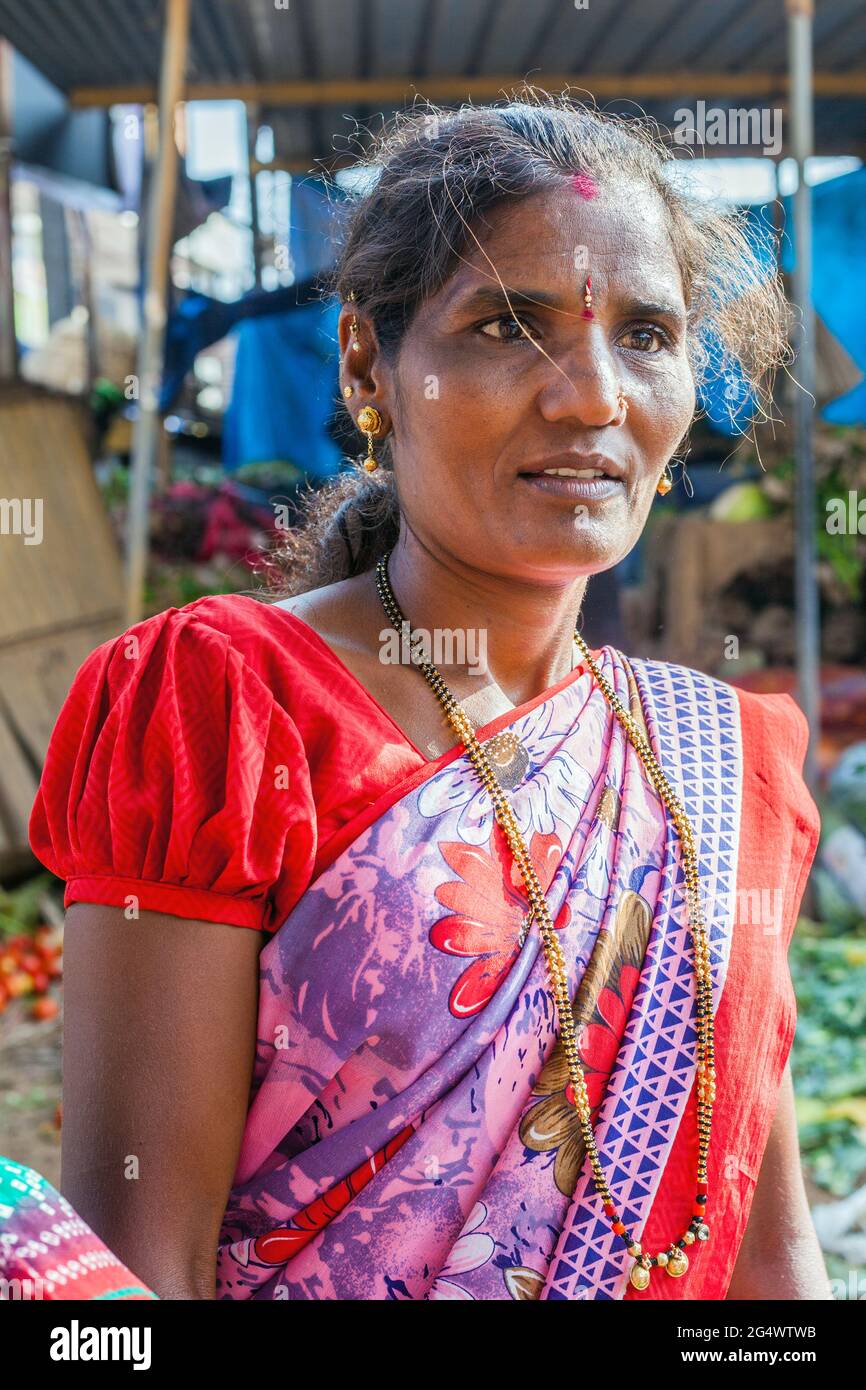 Close u[p portrait of Indian female market trader wearing red sari ...
