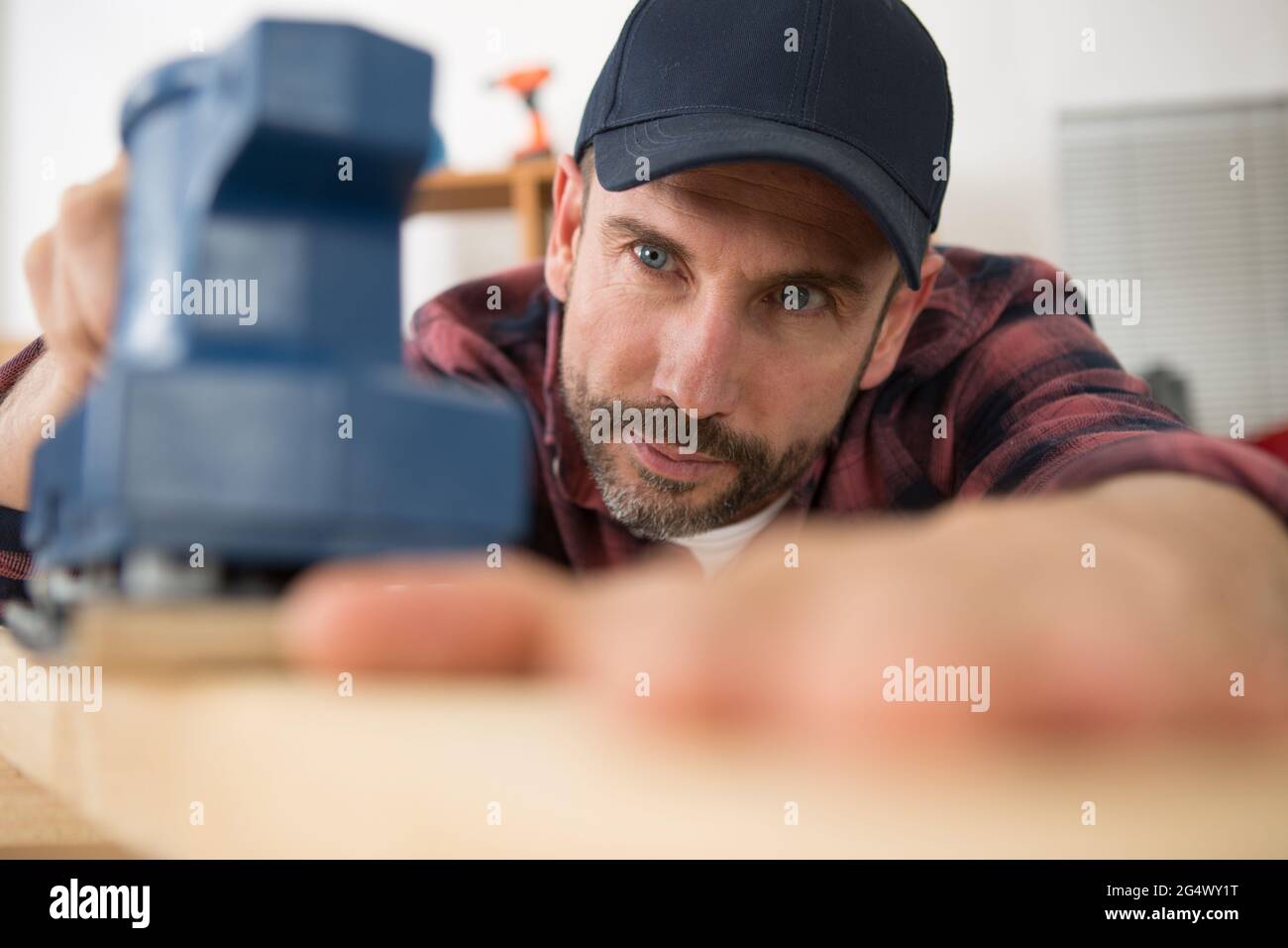 man sanding a wood with sander in a workshop Stock Photo - Alamy
