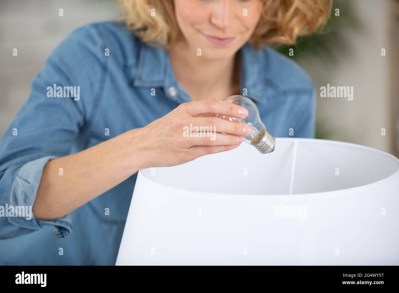 woman changing light bulb in lamp indoors Stock Photo - Alamy