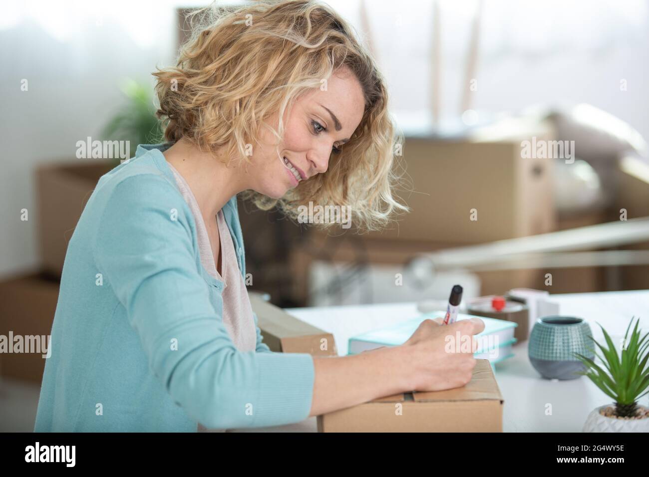 One woman pack boxes hi-res stock photography and images - Alamy