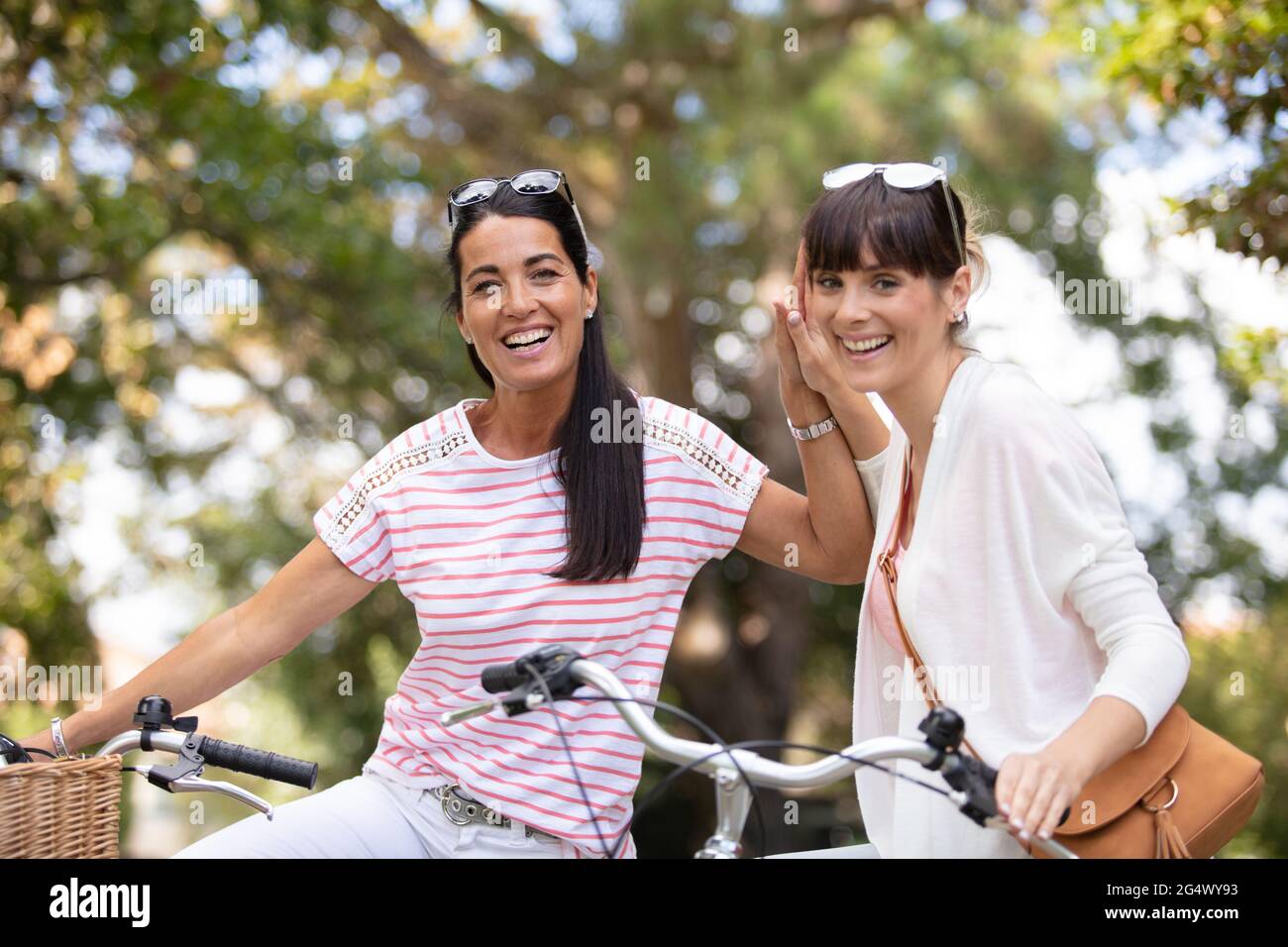two friends on bikes outdoors smiling Stock Photo - Alamy