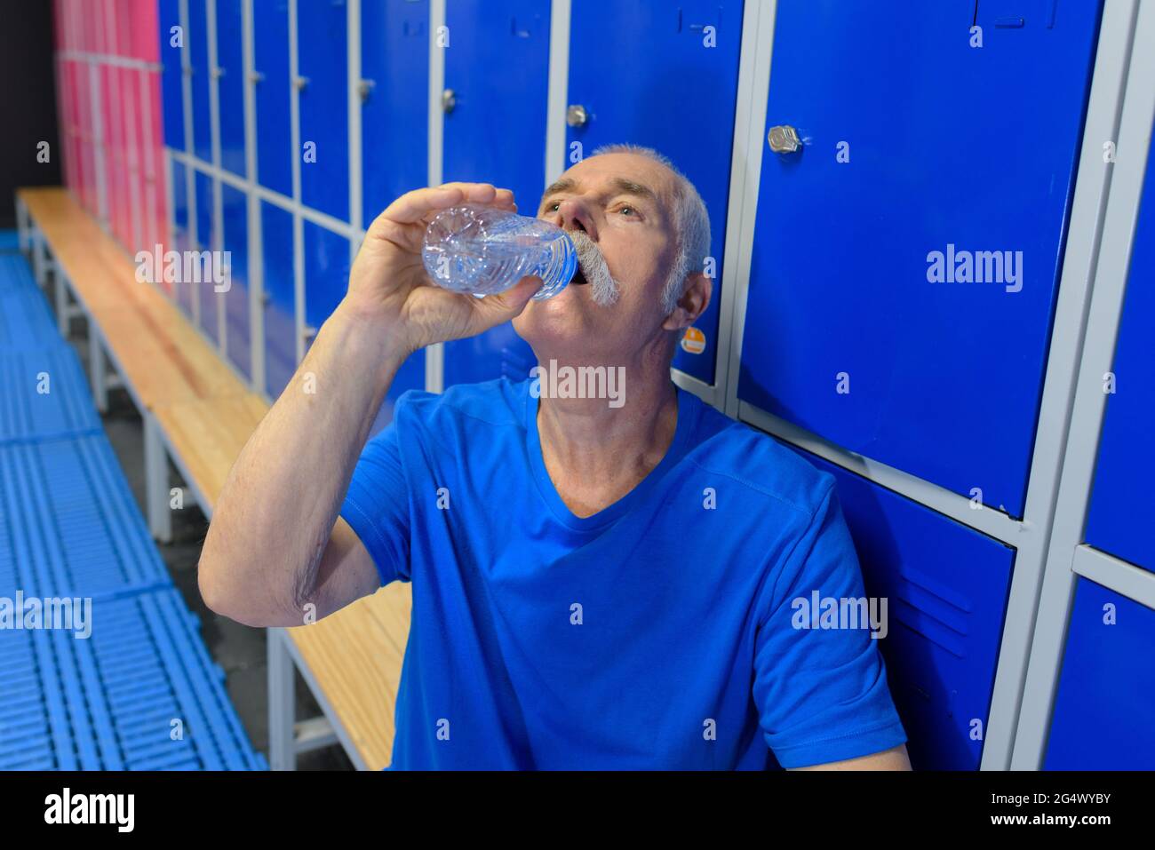 man drinking water in locker-room Stock Photo - Alamy
