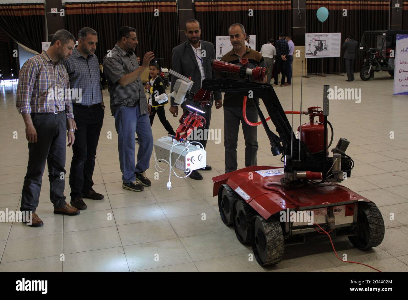 Gaza. 23rd June, 2021. Visitors look at a multi-tasking robot at a ...