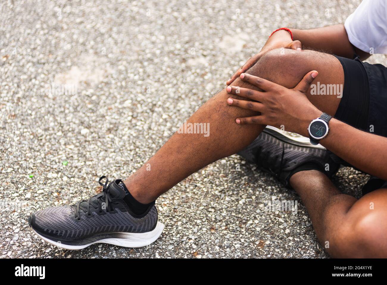 Close up Asian sport runner black man wear watch sitting he uses hands ...